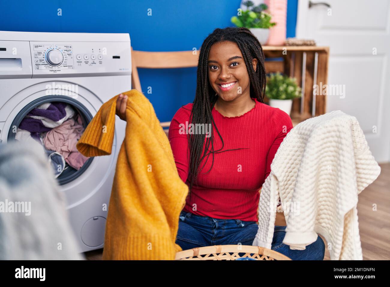 African american woman smiling confident washing clothes at laundry ...