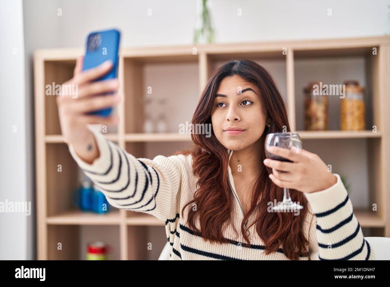 Hispanic young business woman taking a selfie picture drinking a glass ...