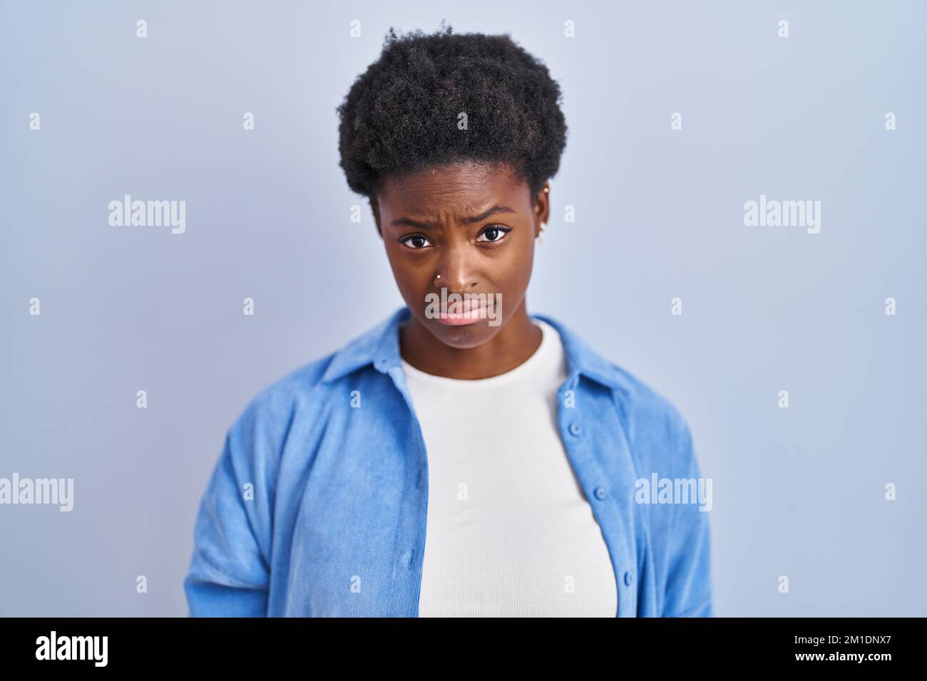 African american woman standing over blue background depressed and ...