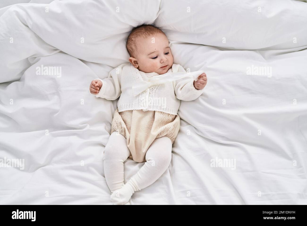 Adorable baby relaxed lying on bed at bedroom Stock Photo - Alamy
