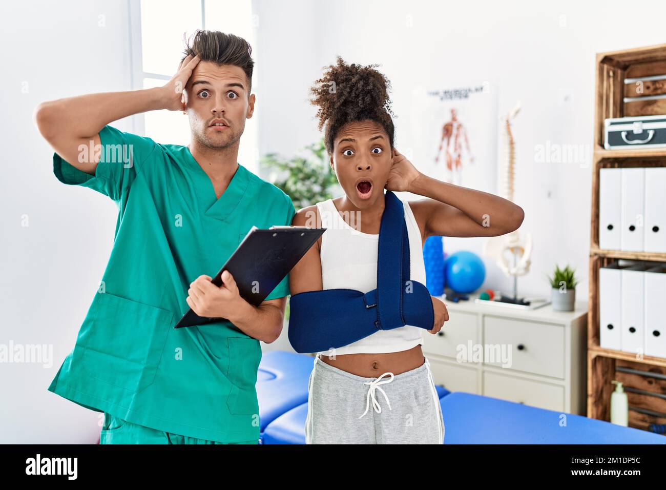 Physiotherapist working with patient wearing arm on sling at ...
