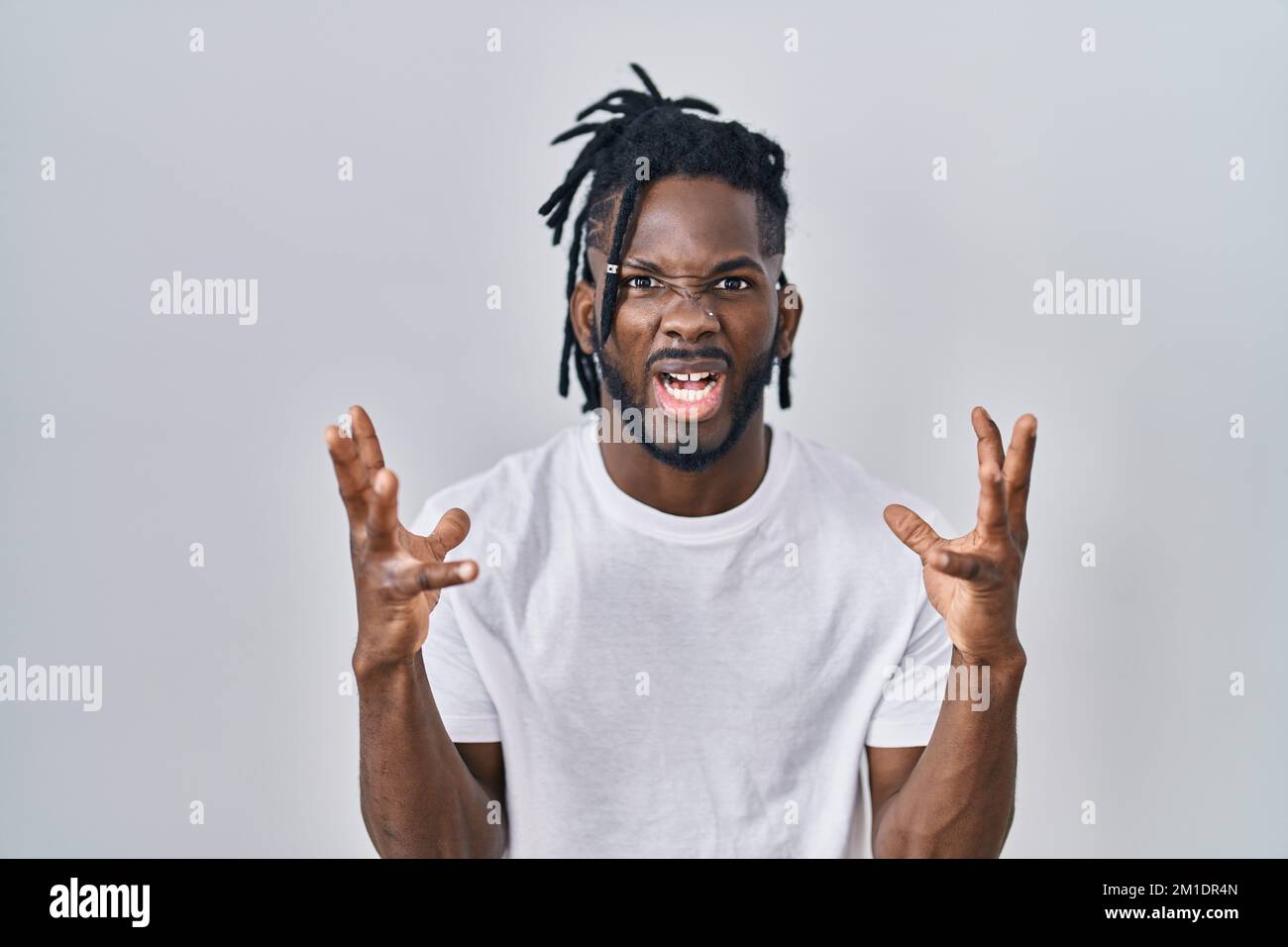 African man with dreadlocks wearing casual t shirt over white ...