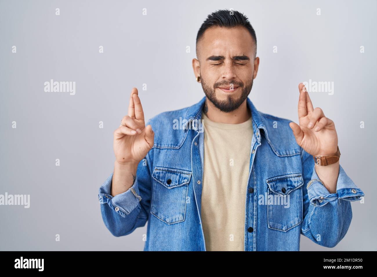 Young hispanic man standing over isolated background gesturing finger ...