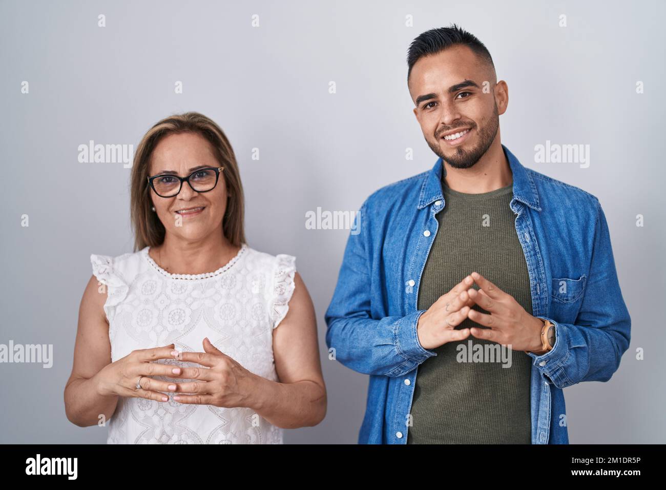 Hispanic mother and son standing together hands together and fingers ...