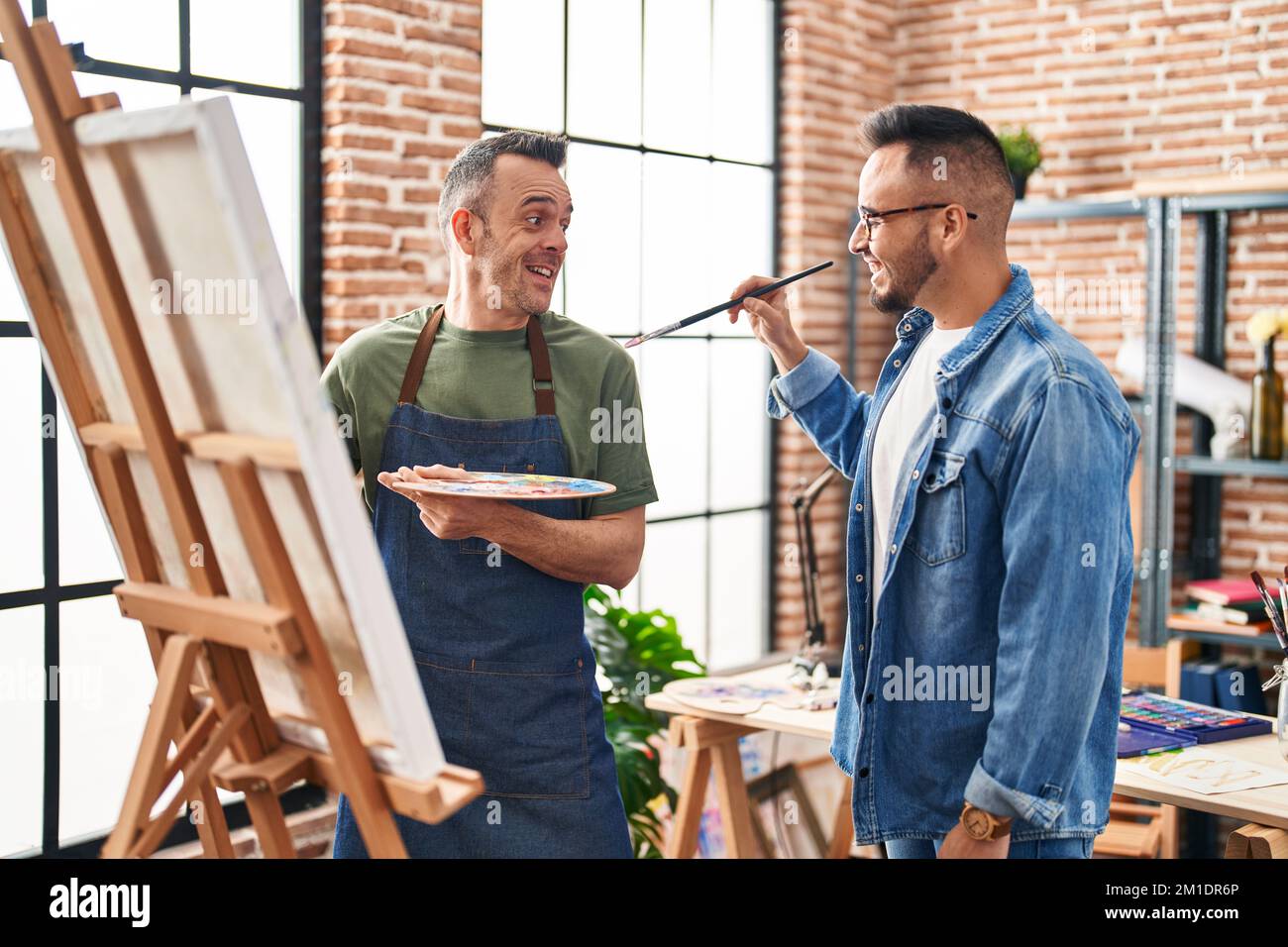 Two men artists smiling confident drawing at art studio Stock Photo - Alamy