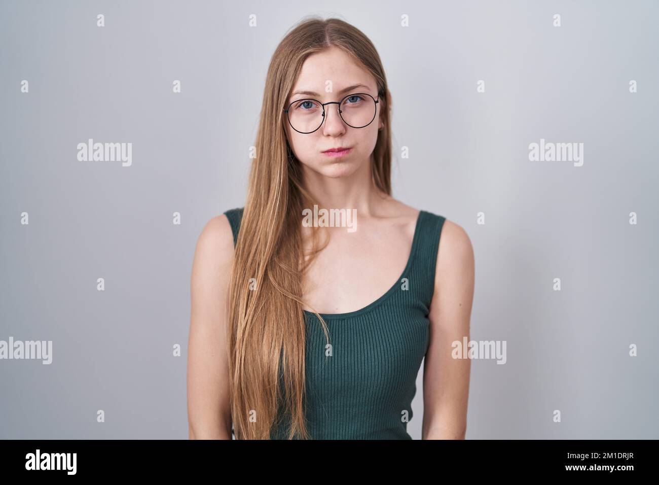 Young caucasian woman standing over white background puffing cheeks ...
