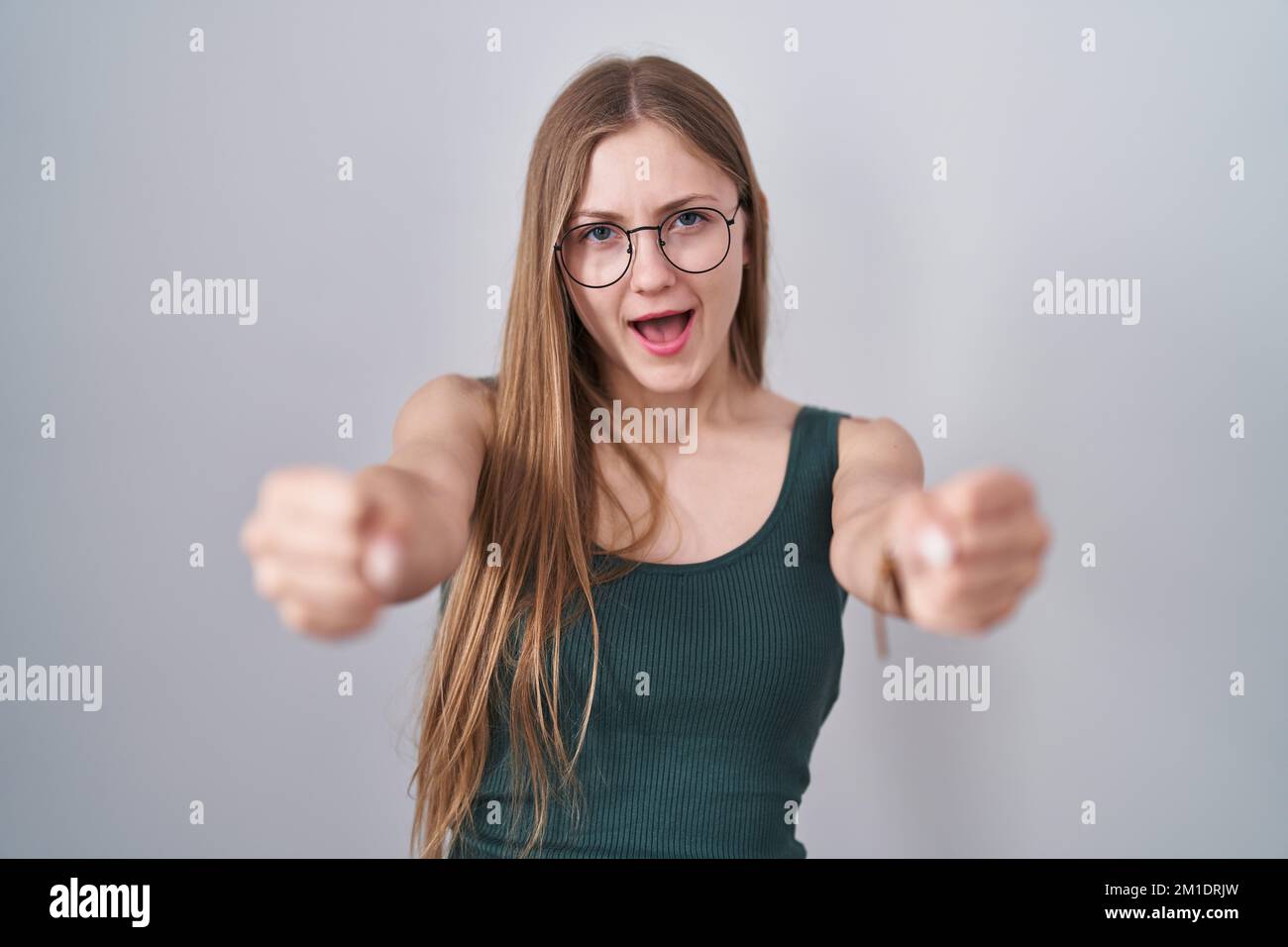Young caucasian woman standing over white background angry and mad ...