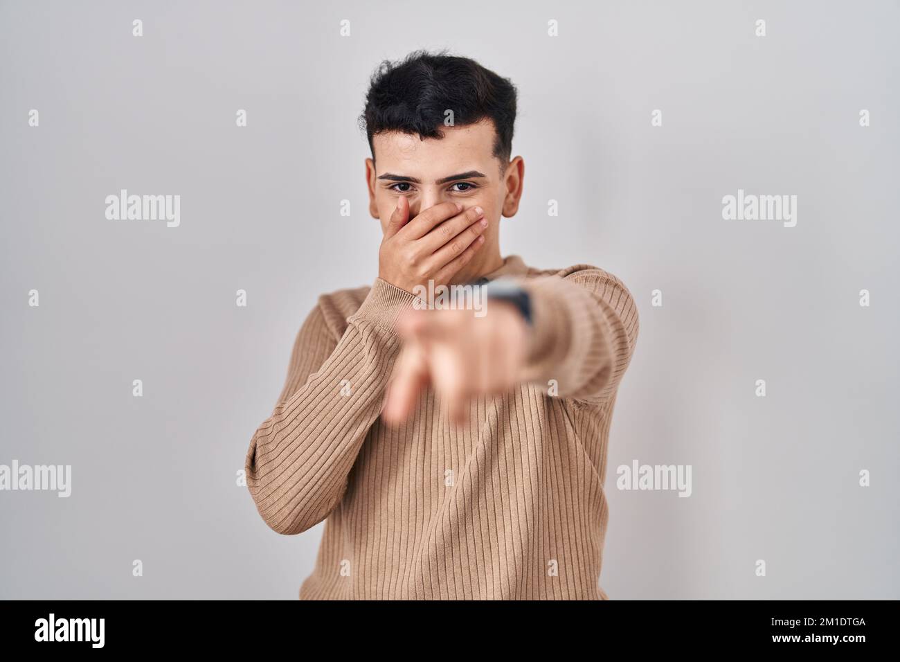 Non binary person standing over isolated background laughing at you ...