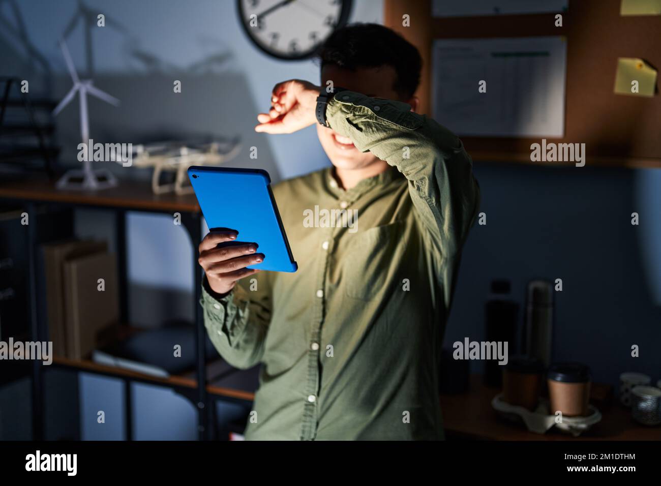 Non binary person using touchpad device at night smiling cheerful ...