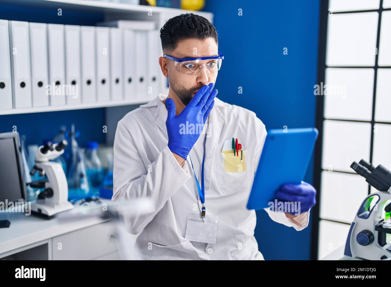 Young handsome man working at scientist laboratory doing online call ...