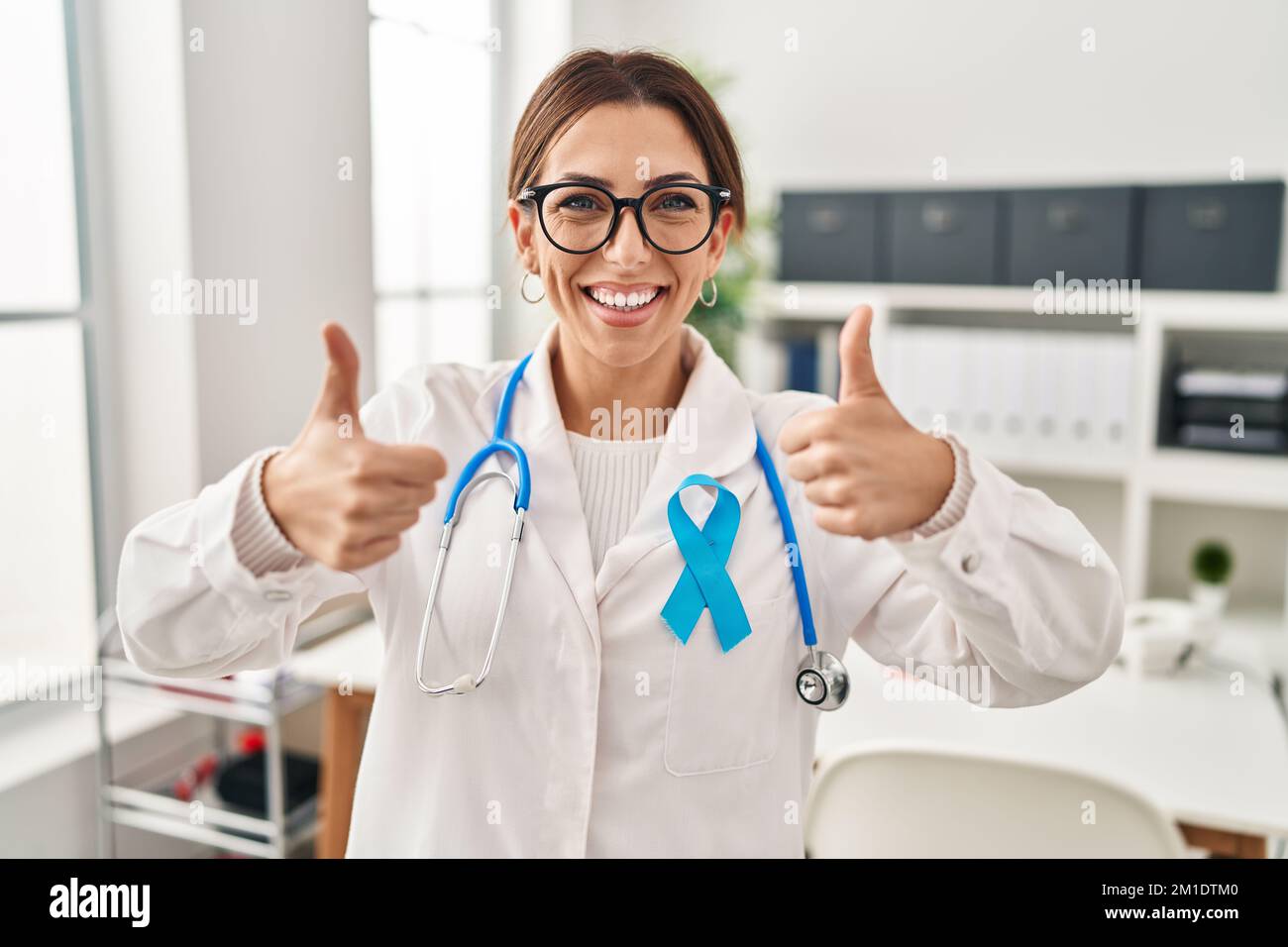 Young brunette doctor woman wearing stethoscope at the clinic success ...