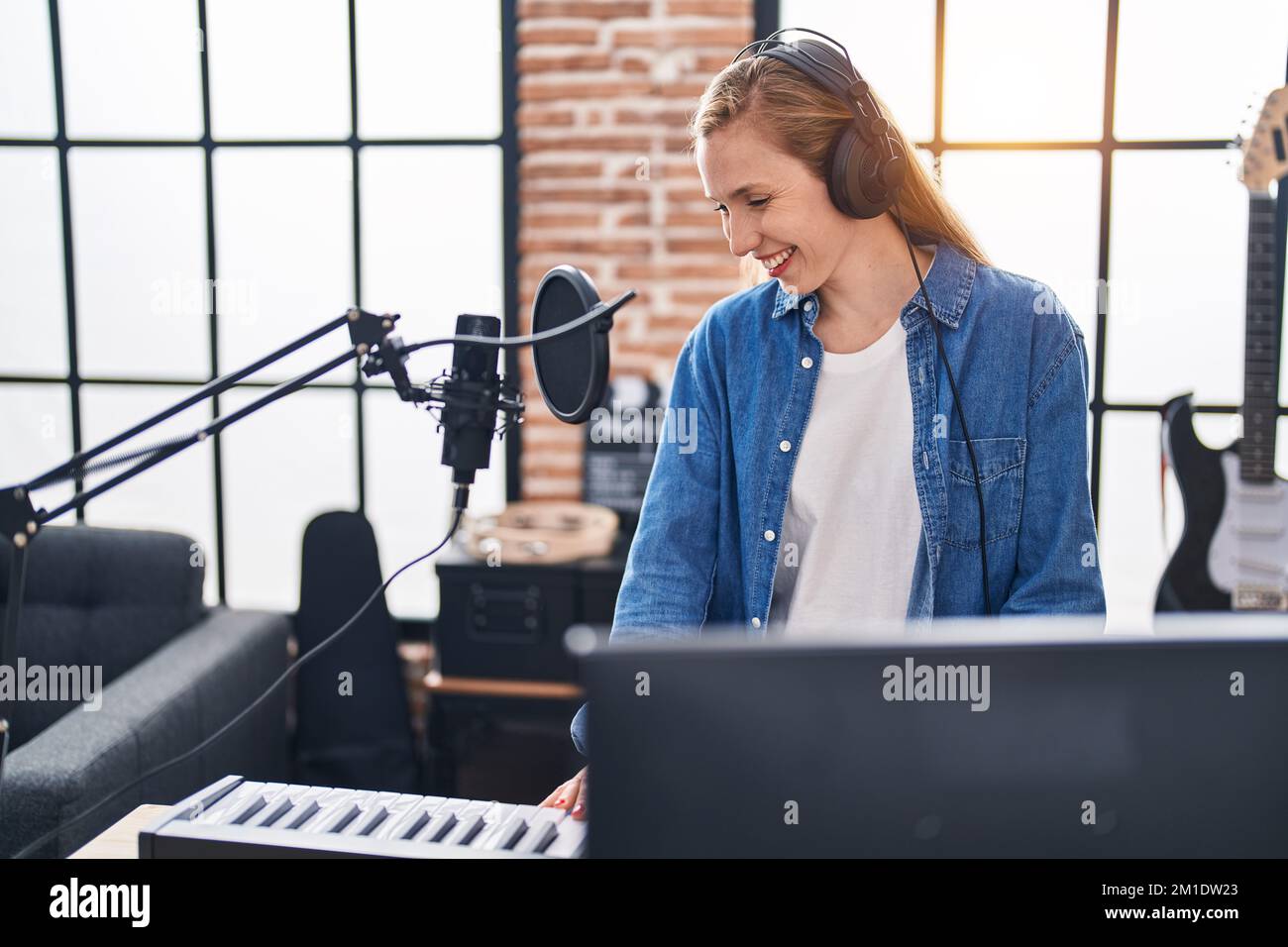 Young blonde woman musician smiling confident singing song at music ...