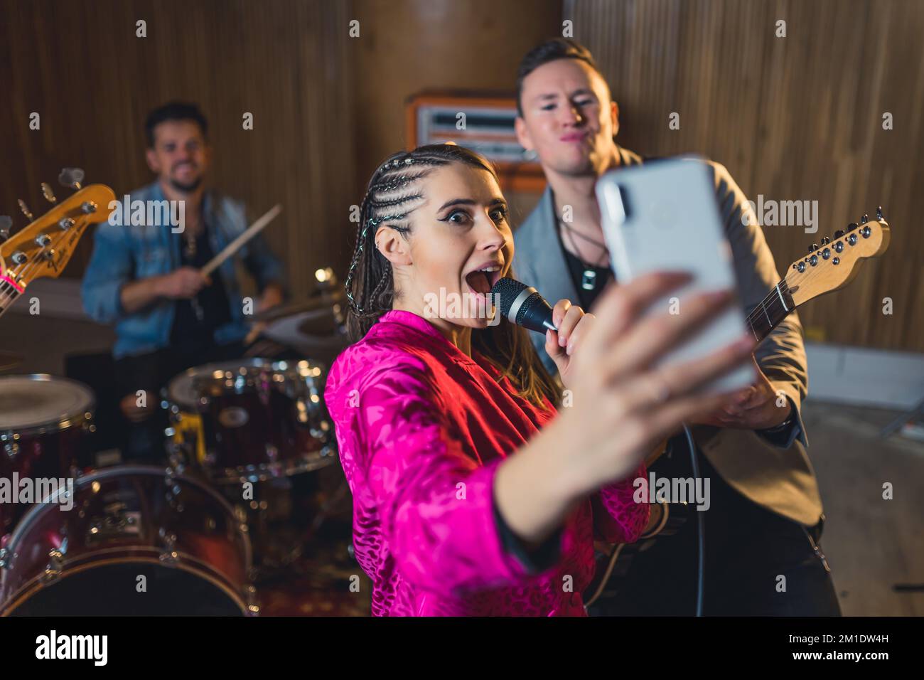Spontaneous funky woman singer takes a selfie with white phone with her ...