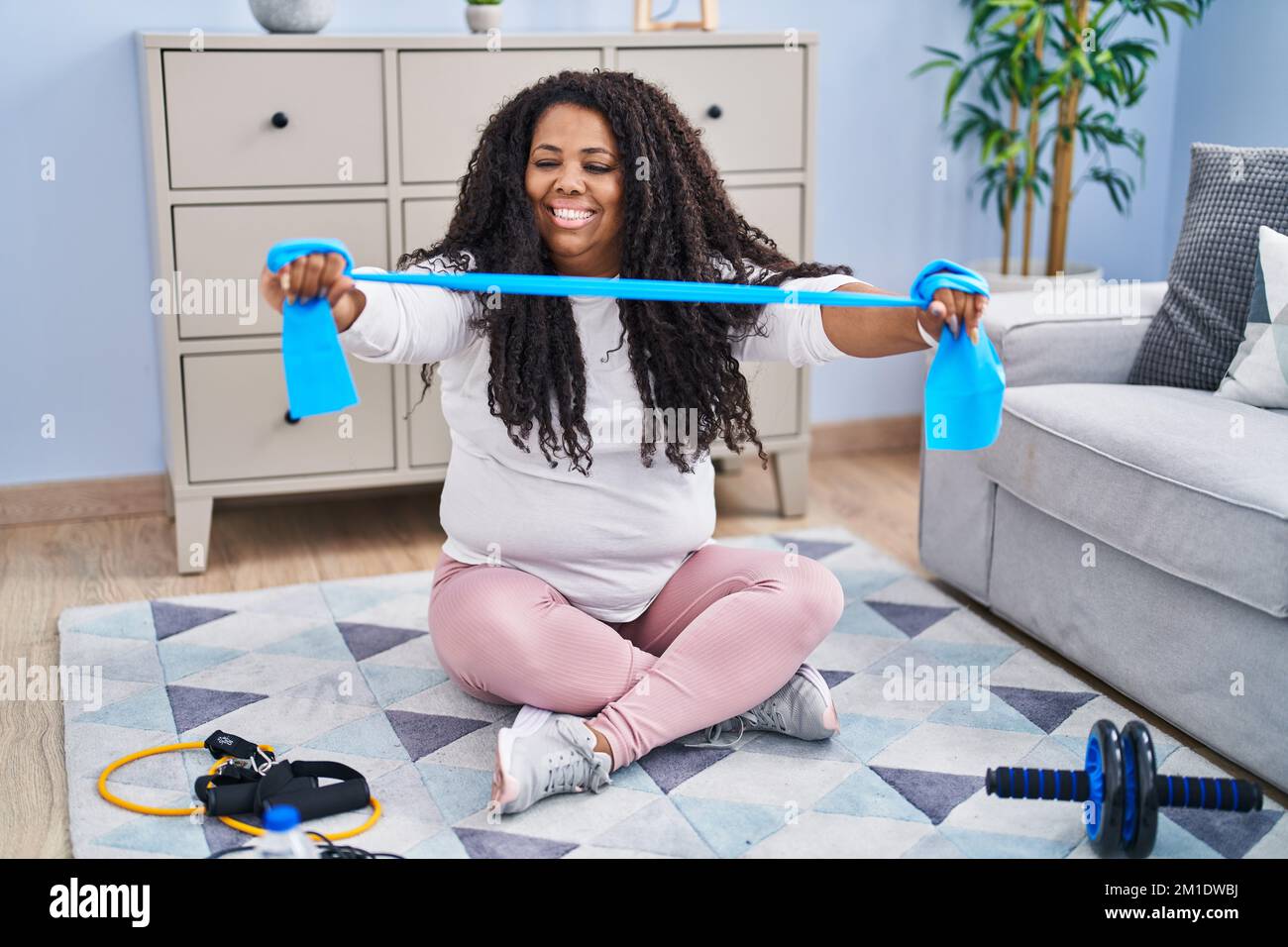 African american woman smiling confident using elastic band training at ...