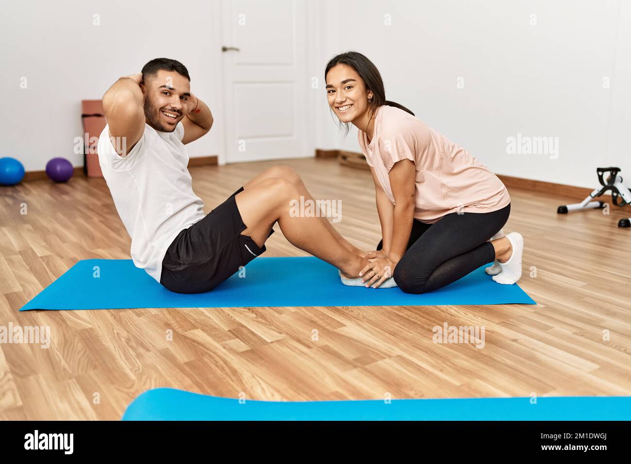 Latin man and woman couple smiling confident training abs exercise at ...