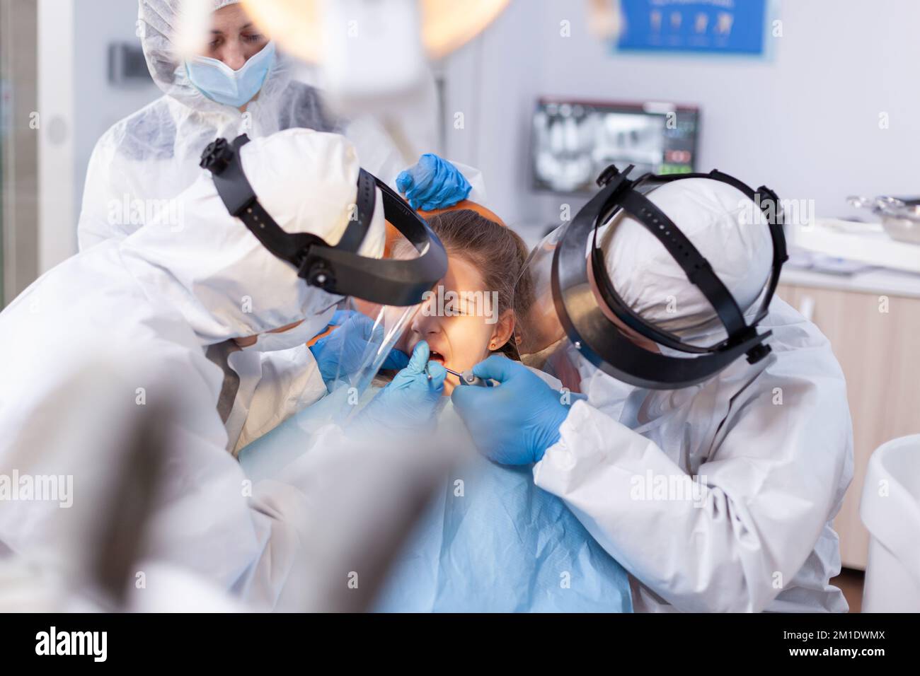 Dentist woman treating little girl bad tooth using drill with help from ...
