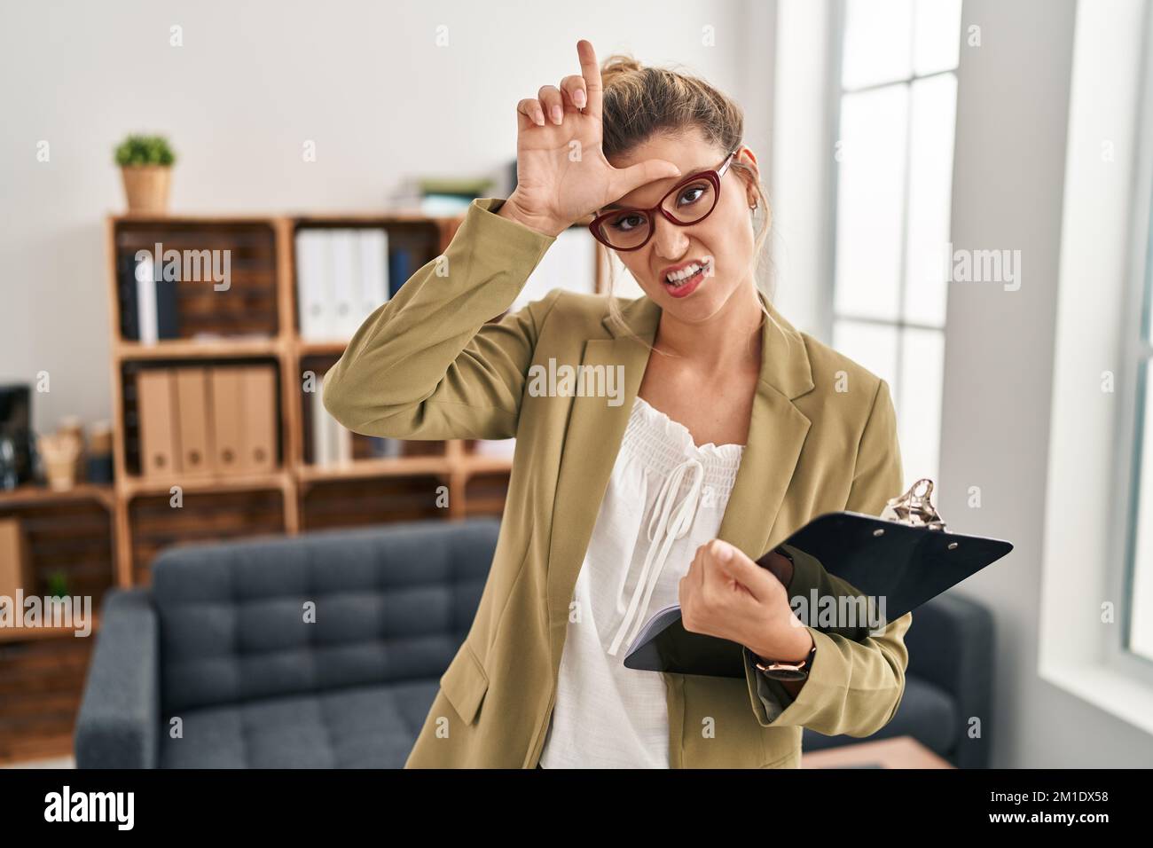 Young woman working at consultation office making fun of people with ...