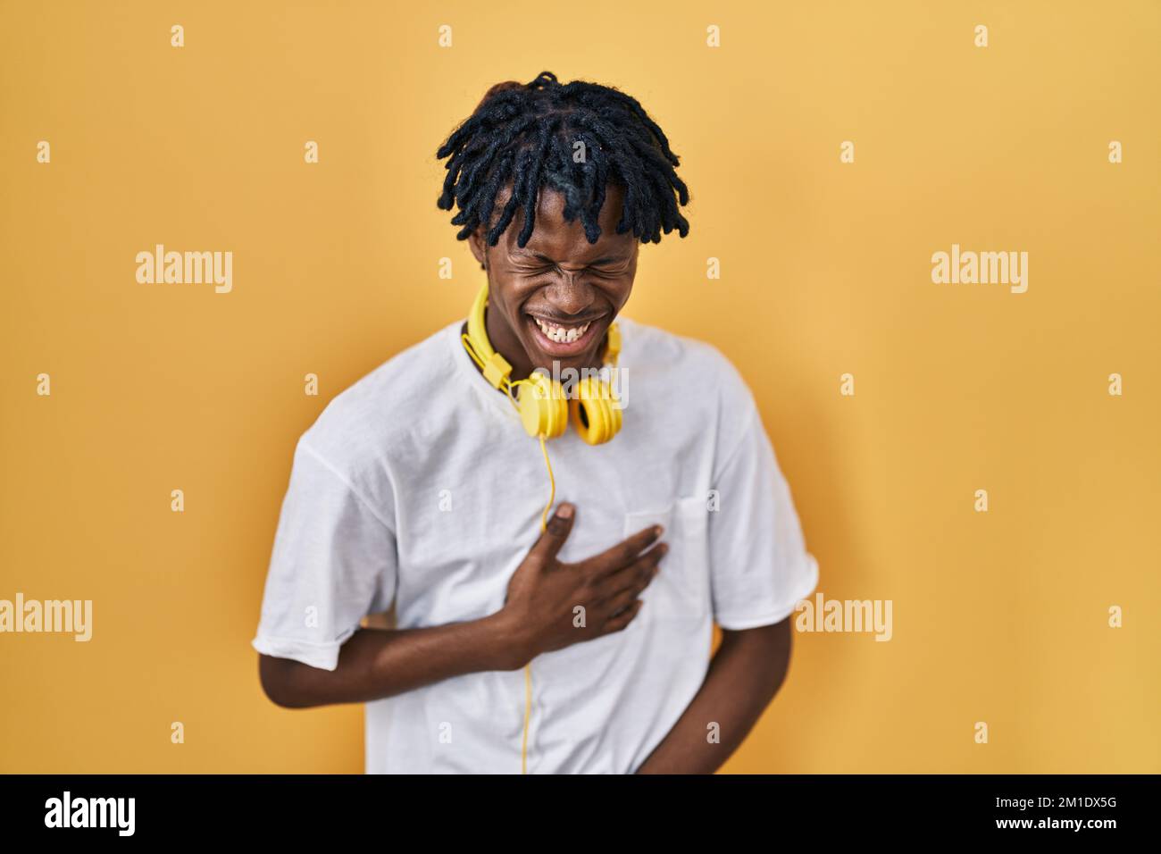 Young african man with dreadlocks standing over yellow background ...