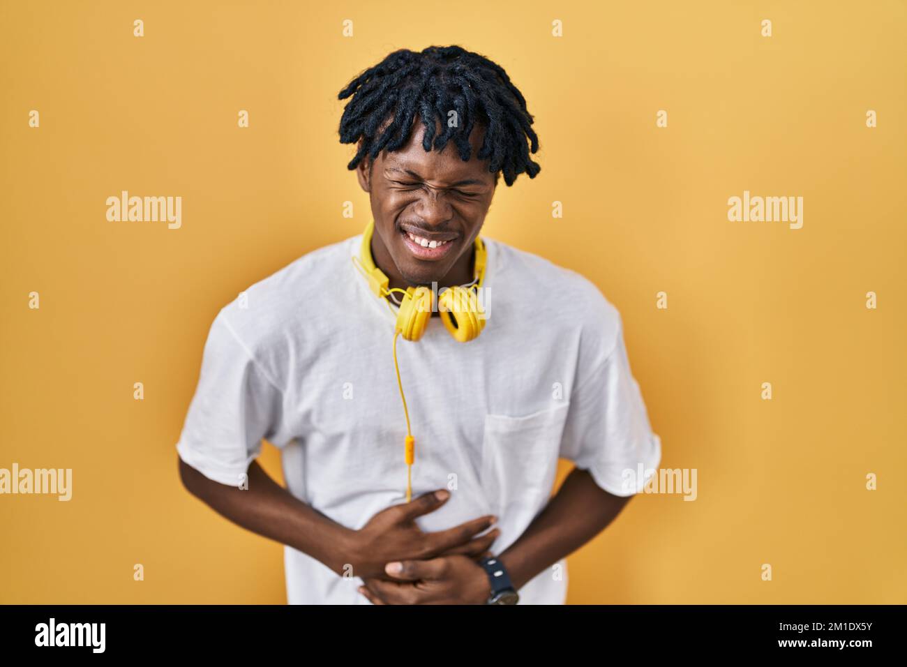 Young african man with dreadlocks standing over yellow background with ...