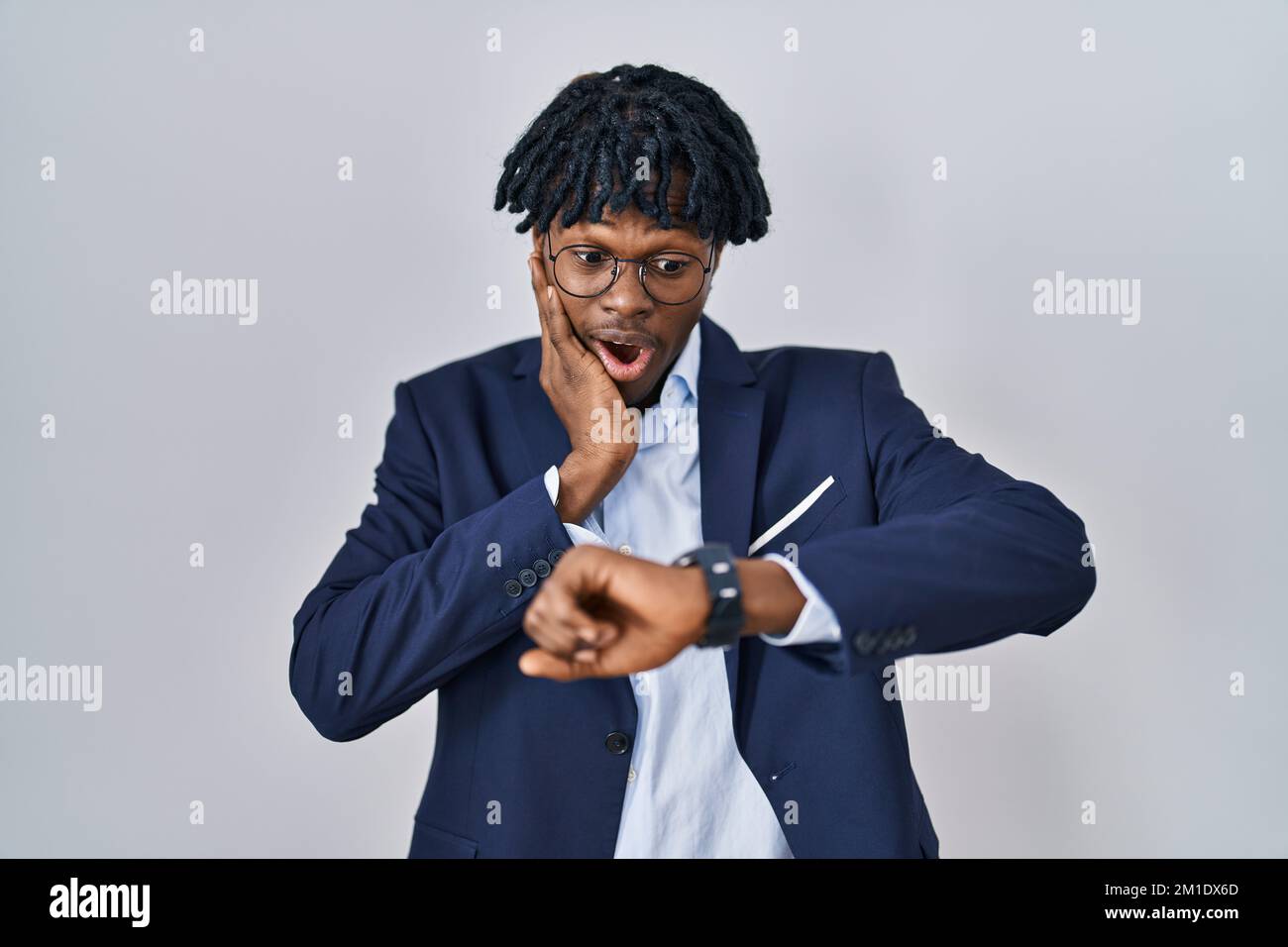 Young african man with dreadlocks wearing business jacket over white ...