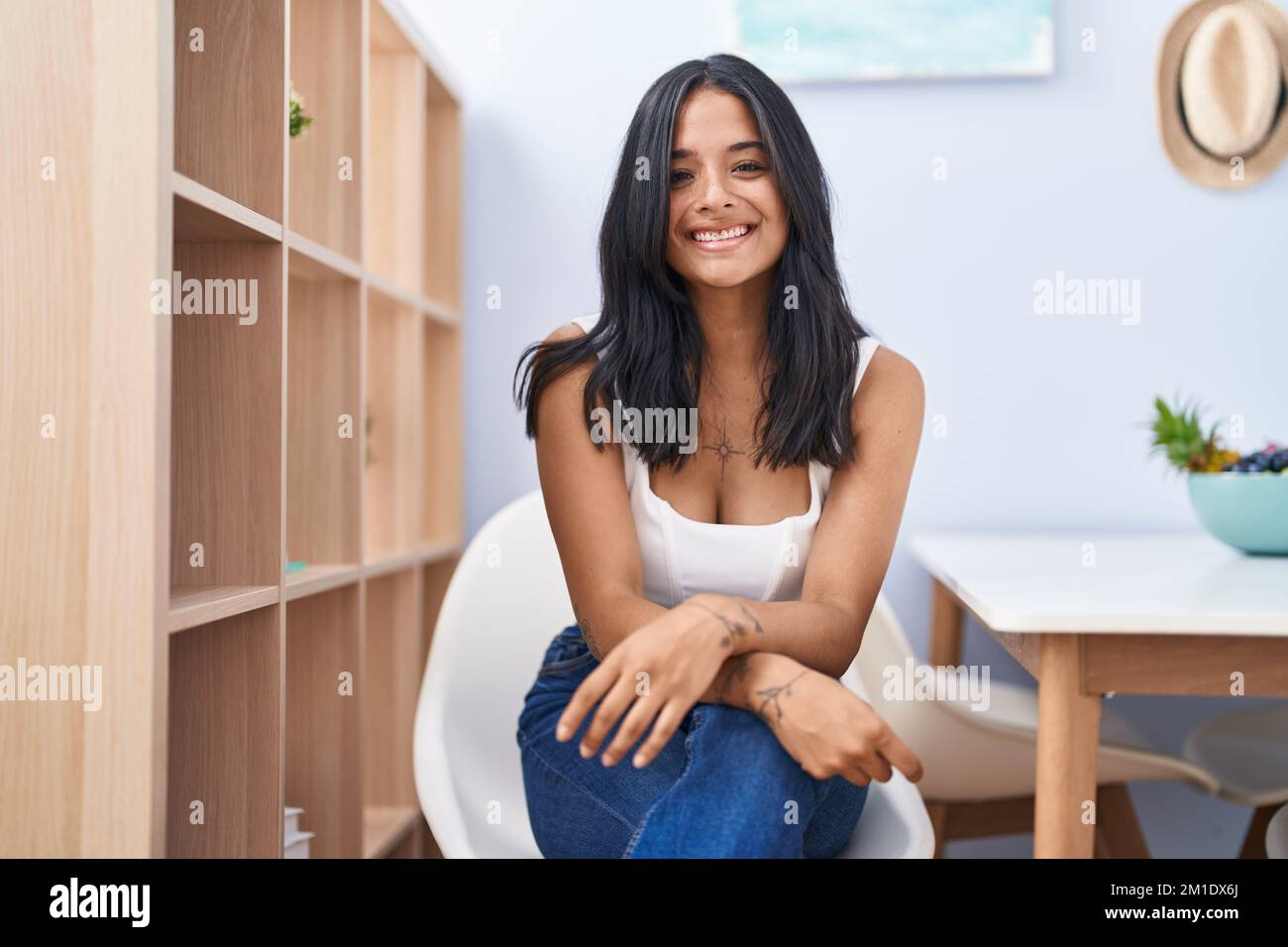 Young hispanic woman smiling confident sitting on chair at home Stock ...