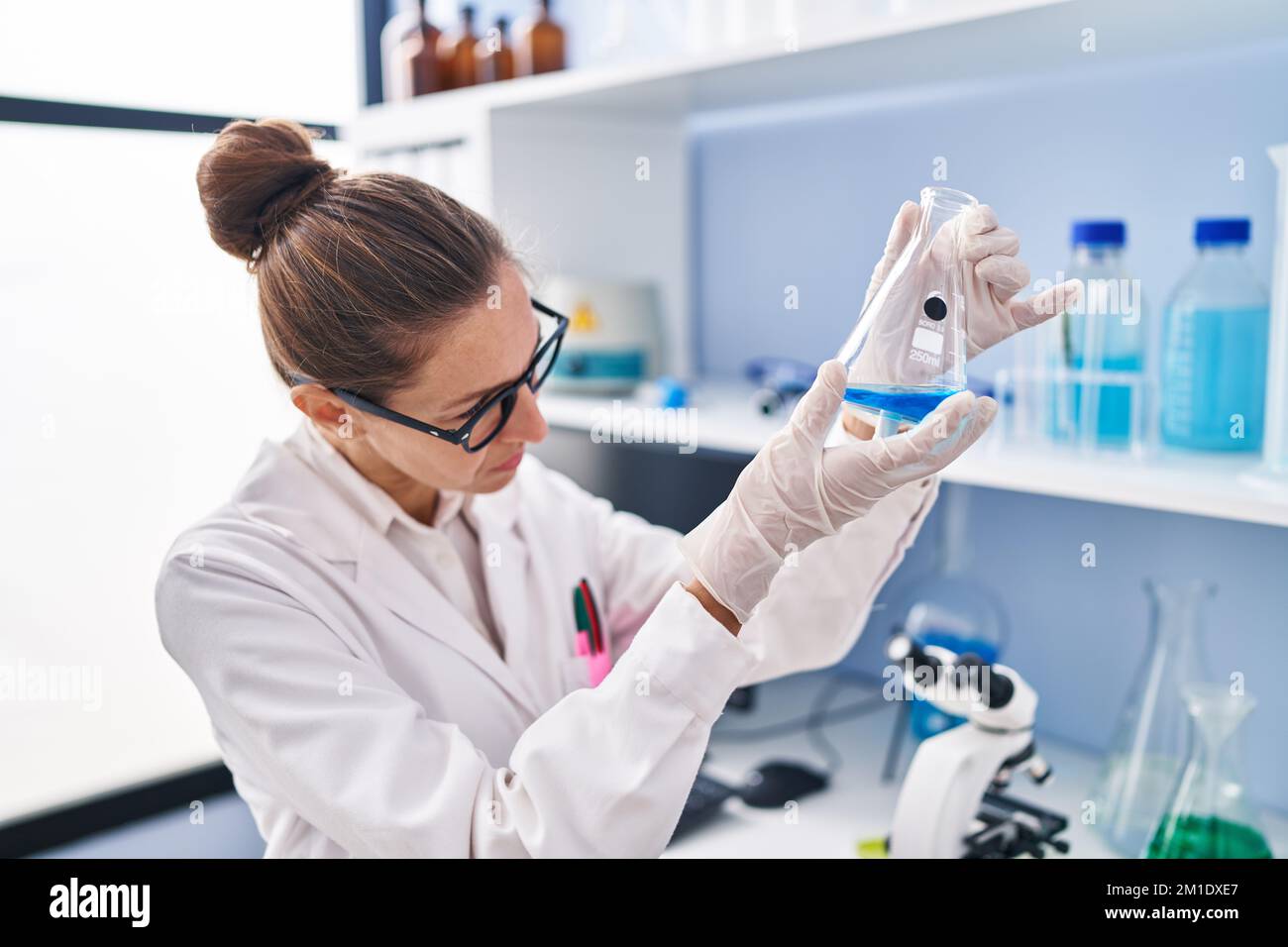 Young woman scientist measuring liquid at laboratory Stock Photo - Alamy