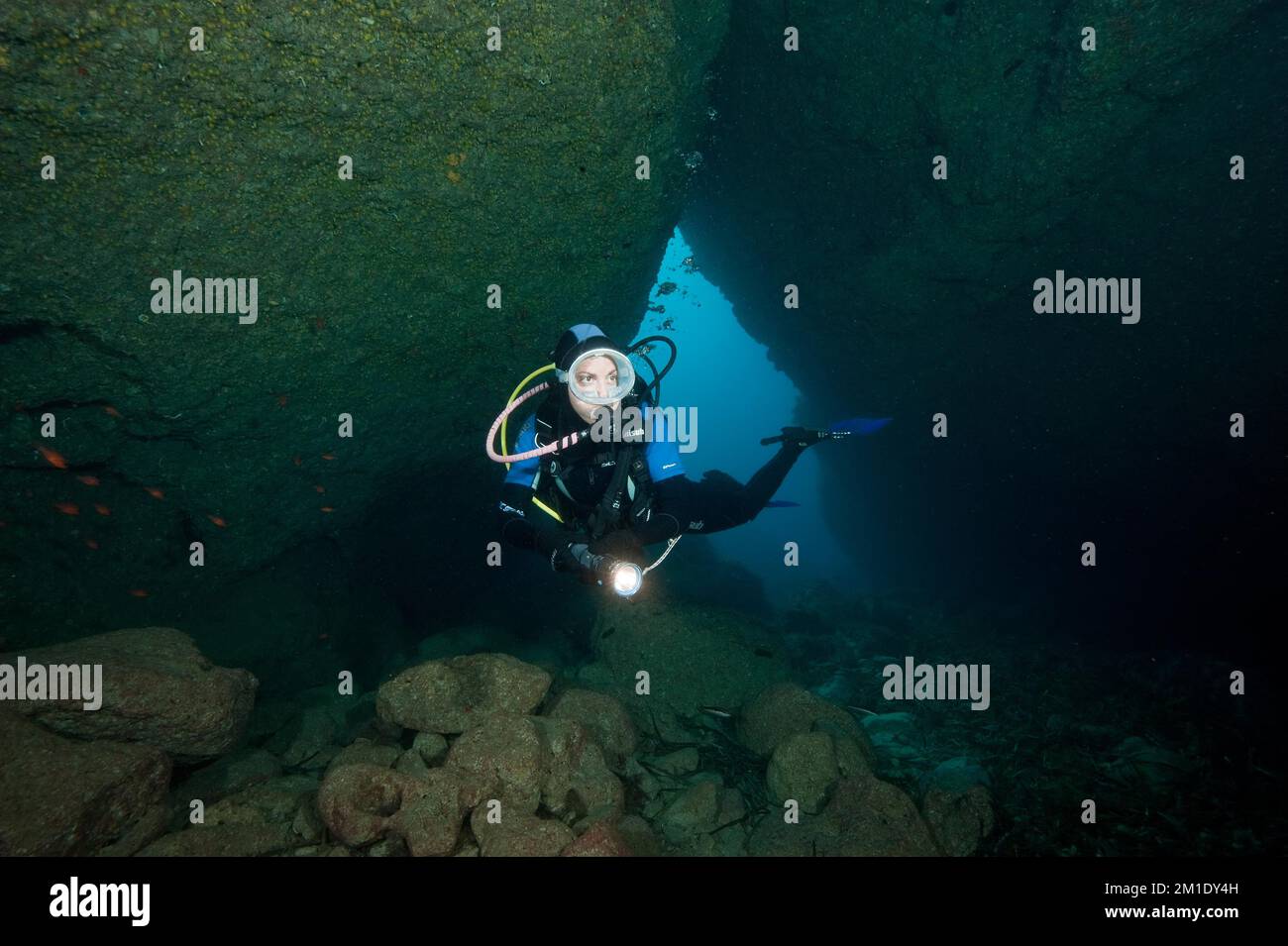 Diver dives through illuminated cave Underwater cave, Mediterranean Sea ...