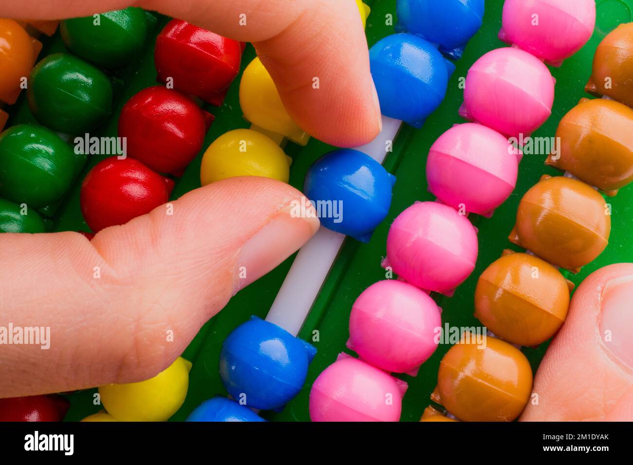 Hand using a color abacus Stock Photo - Alamy