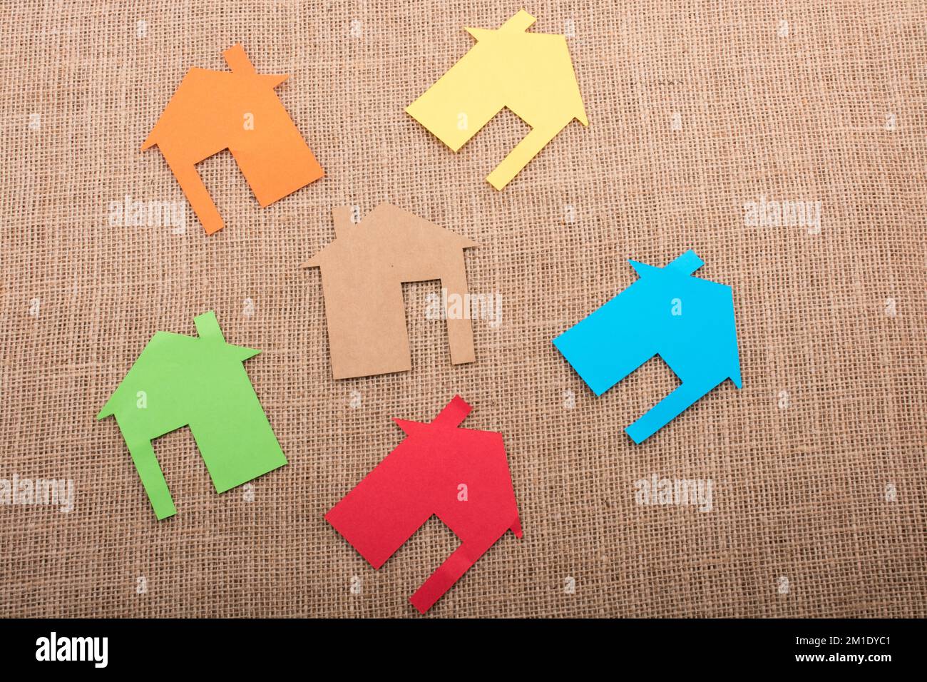 Little house shape cut out of colorful paper on a canvas background ...