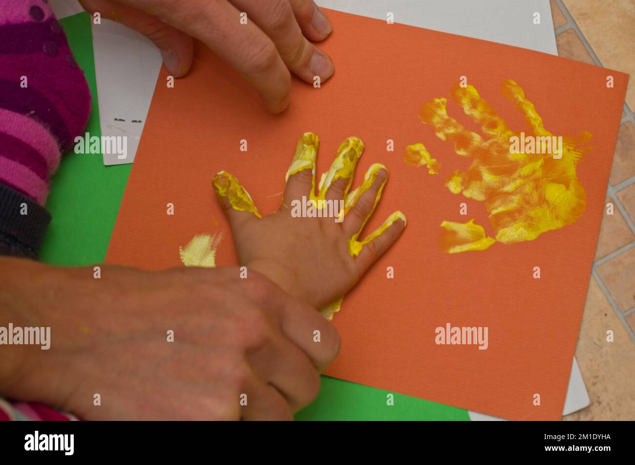 Hand of a little child making a handprint on orange paper Stock Photo ...