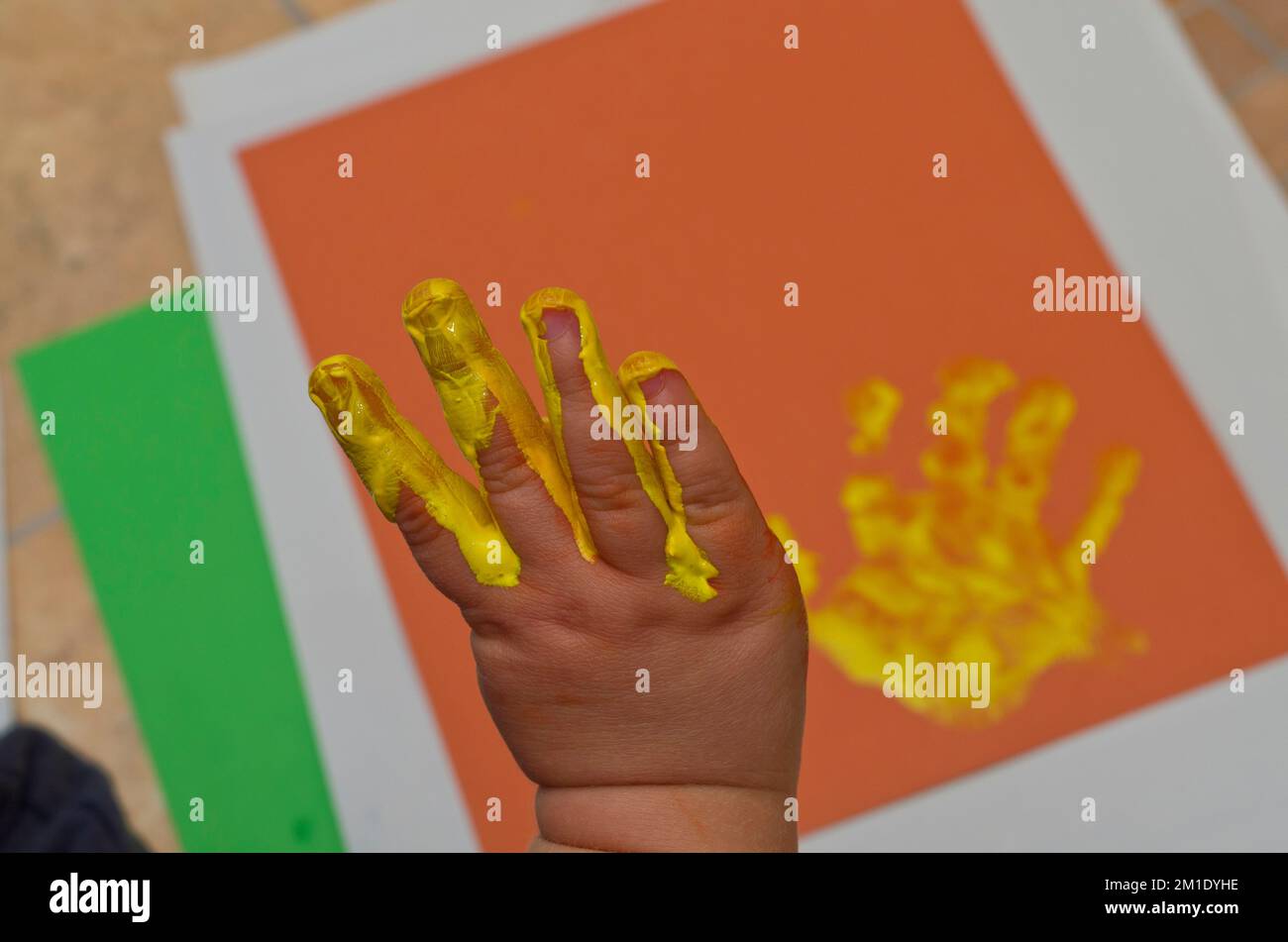 Hand of a little child making a handprint on orange paper Stock Photo ...