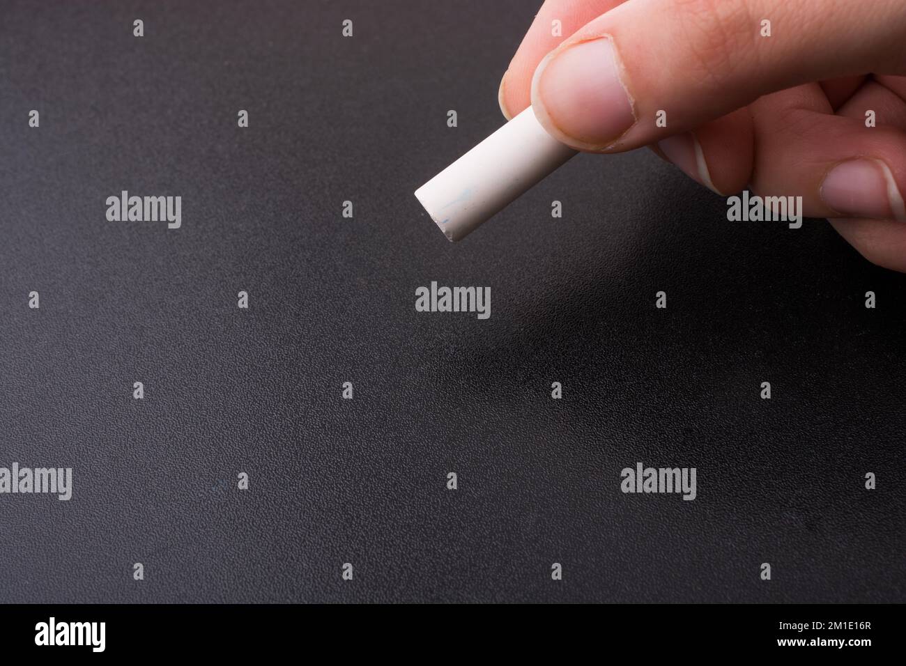 Hand holding white chalk and black board Stock Photo - Alamy