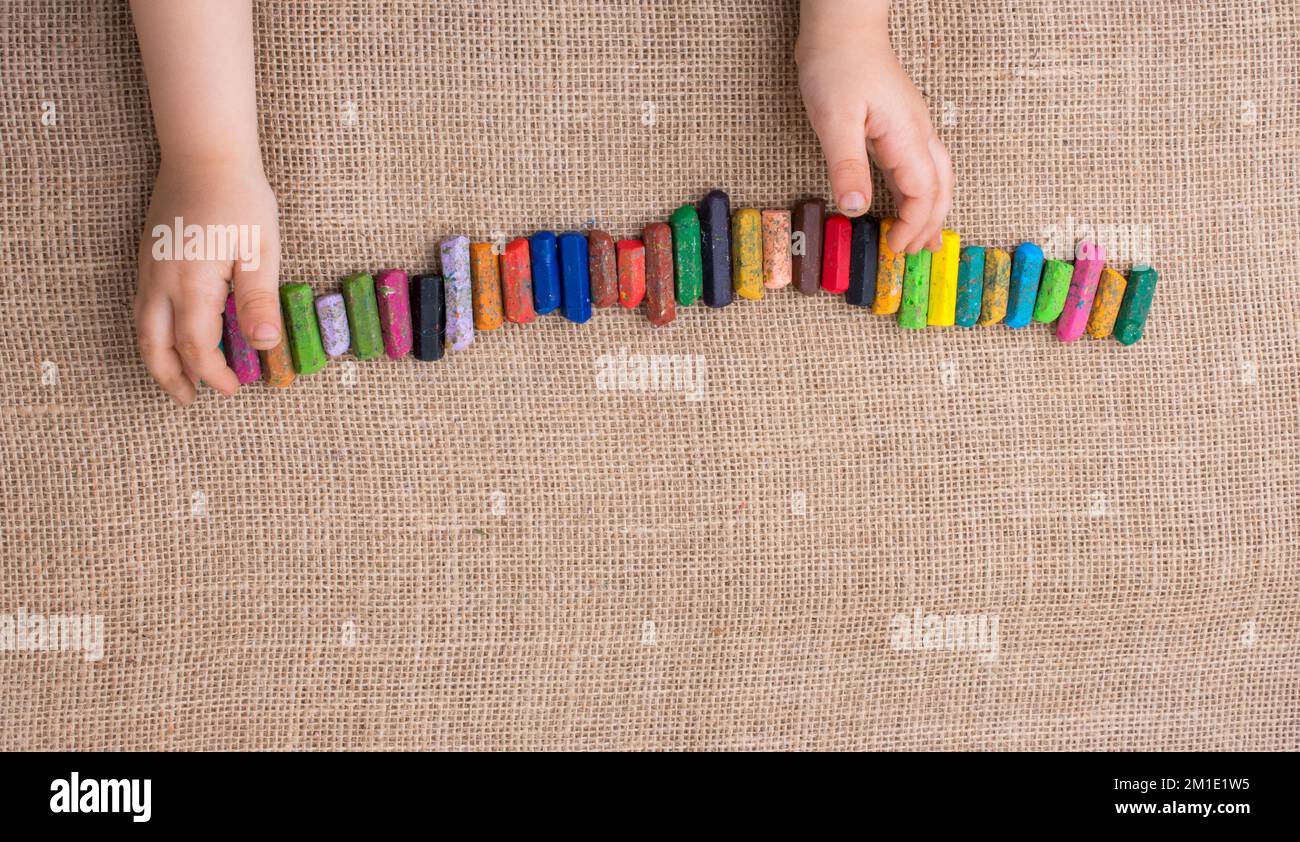 Toddlers hand putting crayons in line on canvas Stock Photo - Alamy