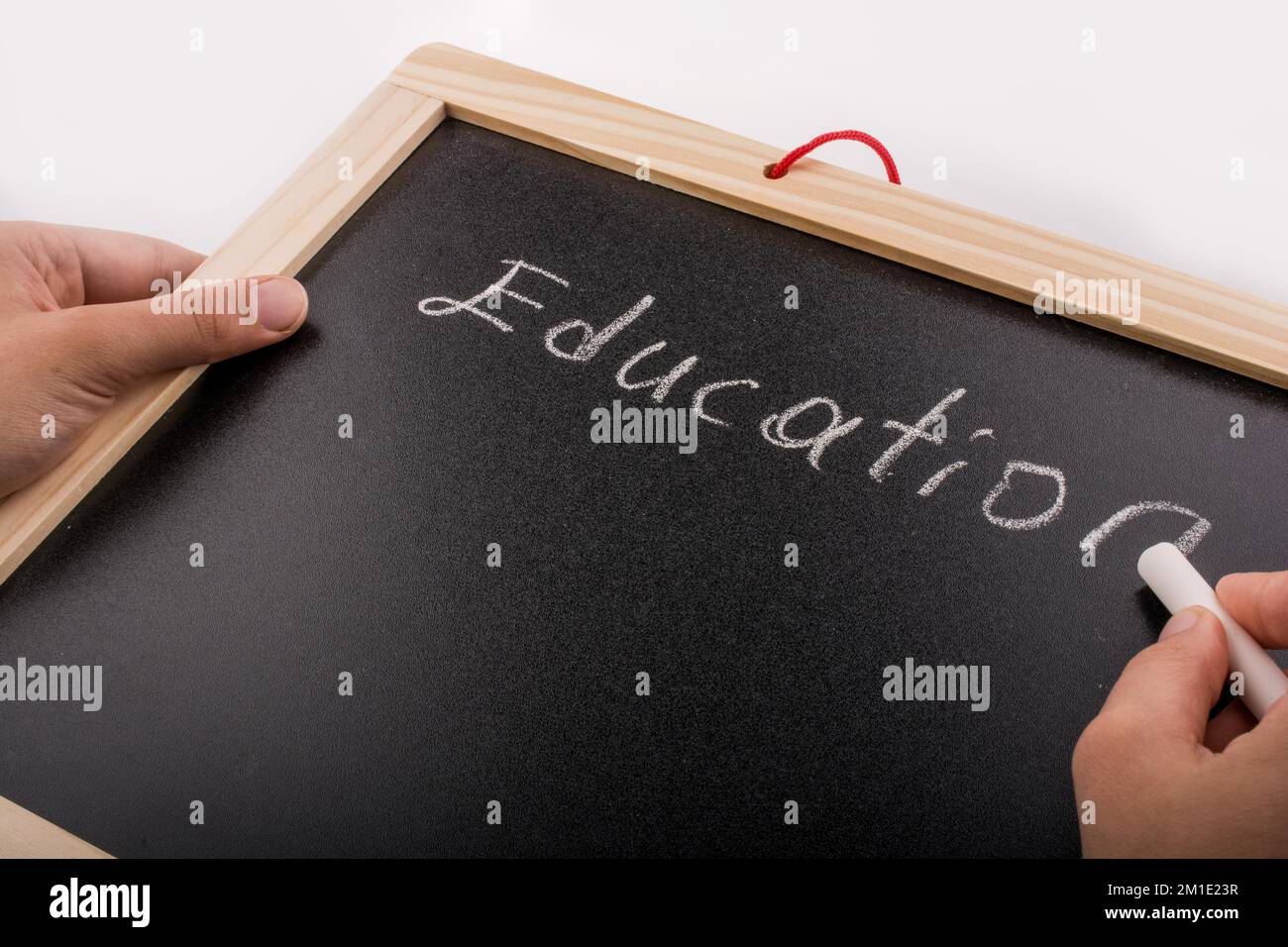 Hand holding a blackboard with 'education' written on it on a white ...