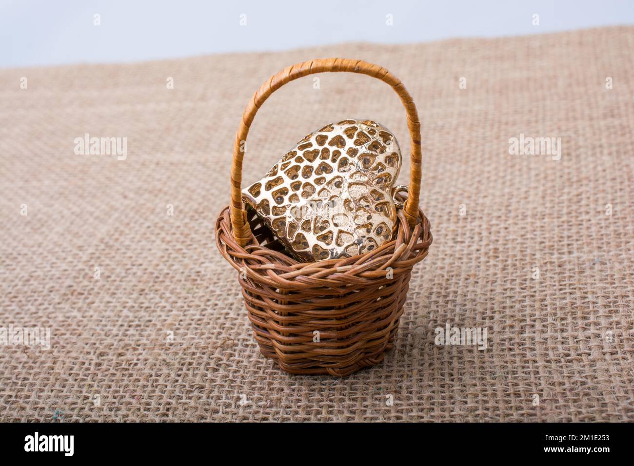 Heart shaped object beside a basket in canvas Stock Photo - Alamy