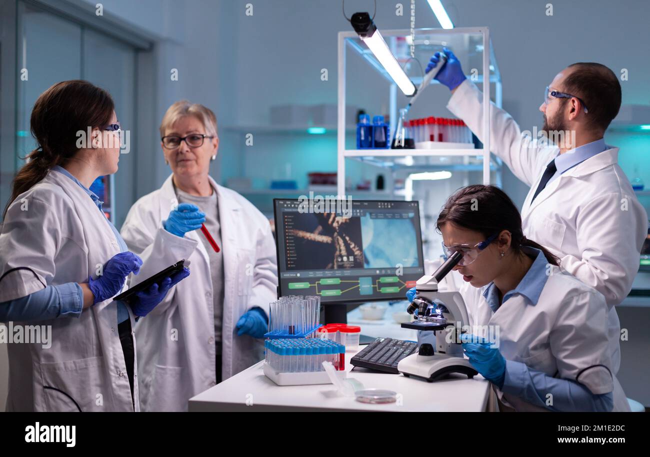 Woman tehnician lab doctor in white coat looking under microscope ...