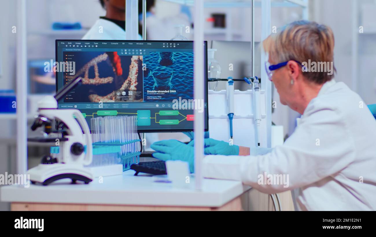Senior woaman biochemist checking manifestations of virus working in ...