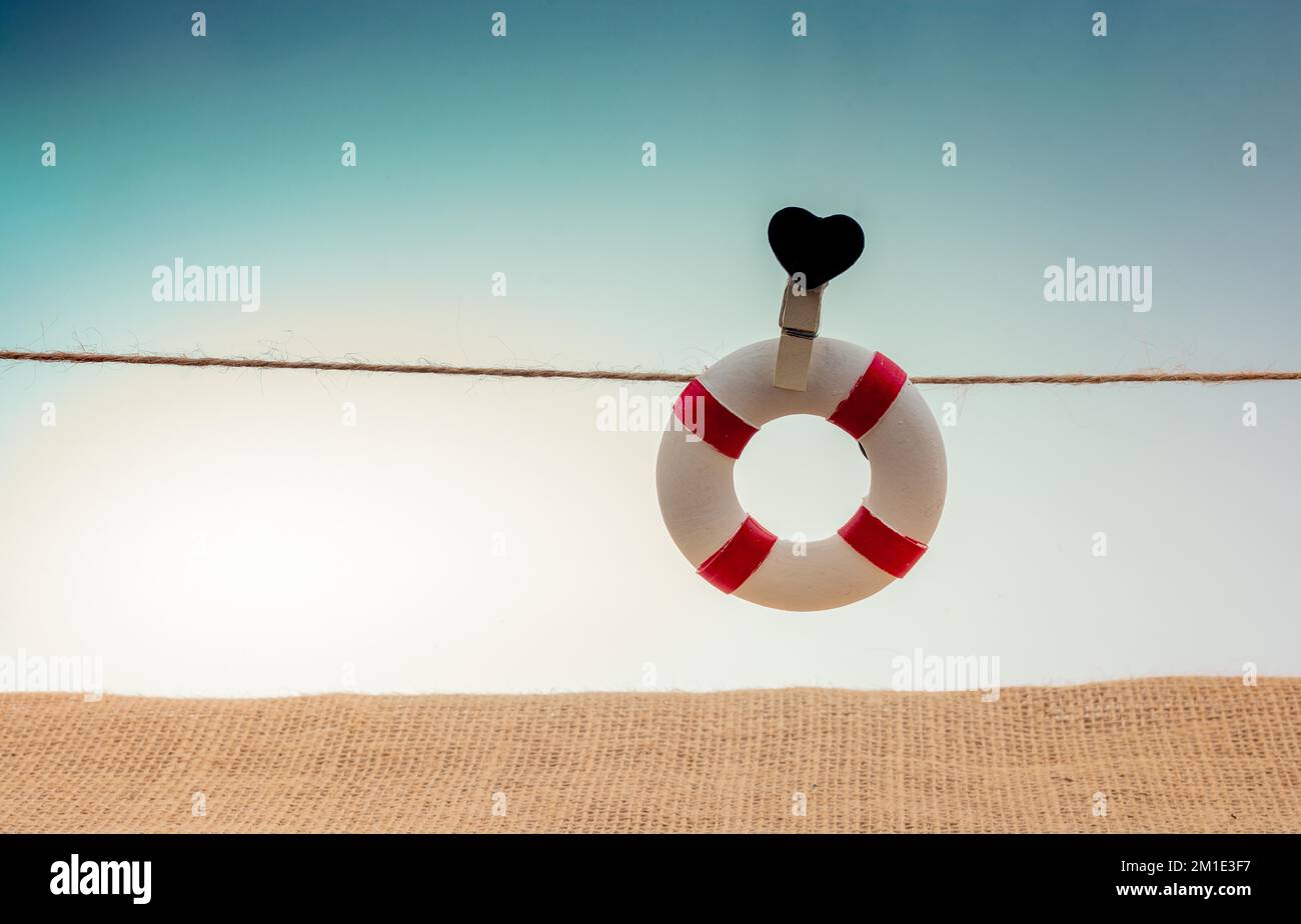 Life preserver attached to a string with heart icon Stock Photo - Alamy