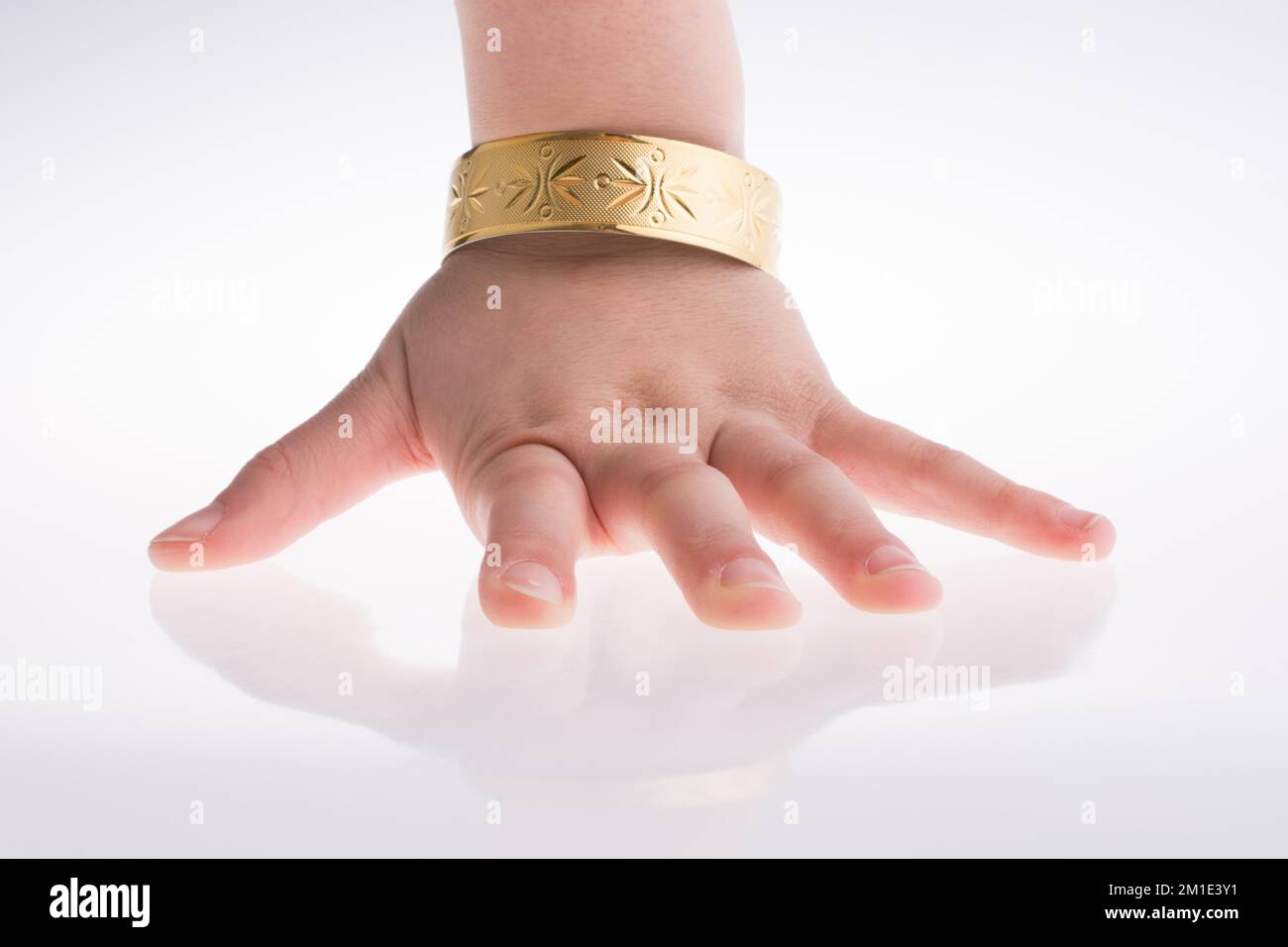 Hand with a golden bracelet on a white background Stock Photo - Alamy