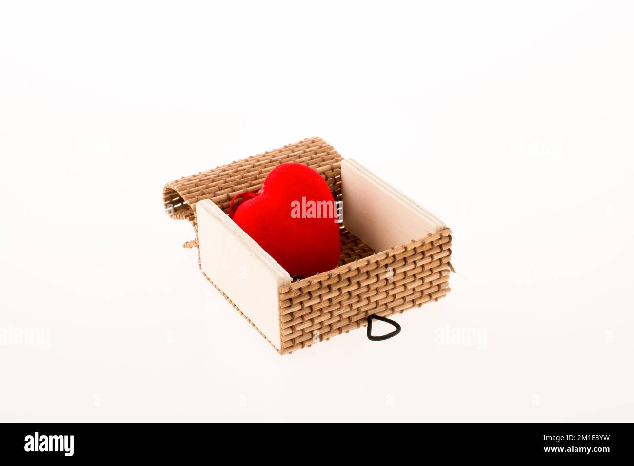Red heart shaped object placed in a straw box on white background Stock ...
