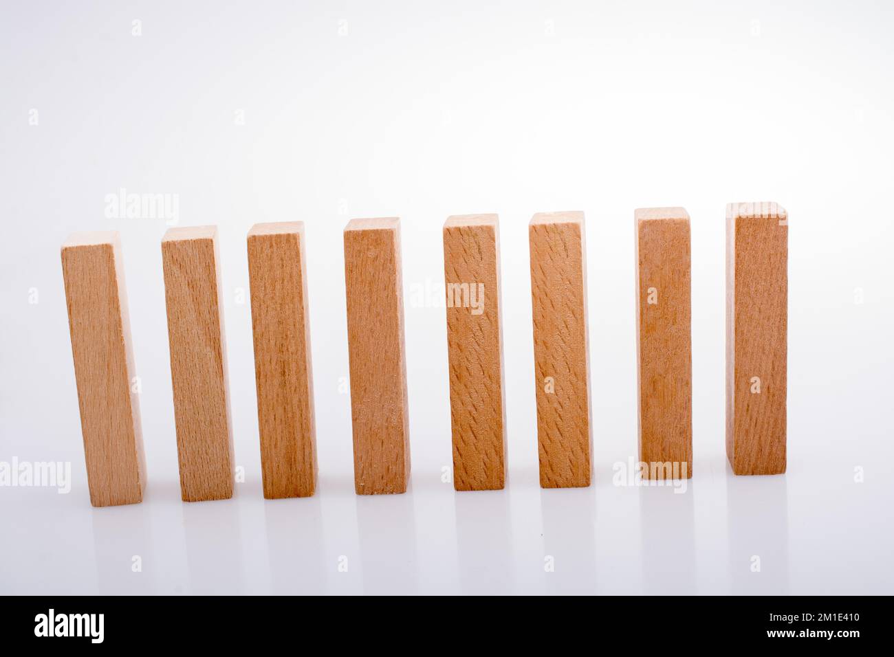 Wooden Domino Blocks in a line on a white background Stock Photo - Alamy