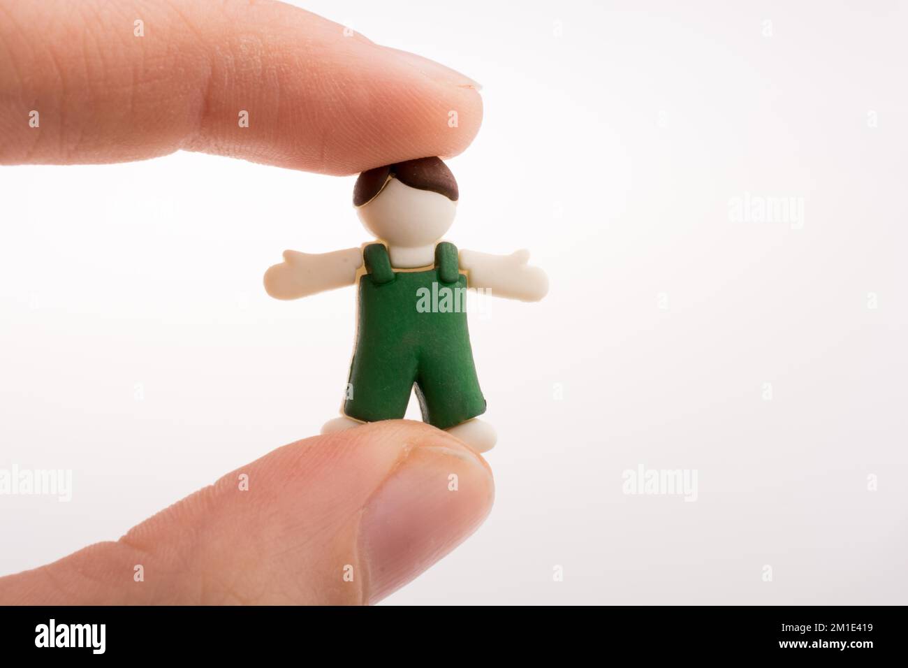 Hand holding a child figure on a white background Stock Photo - Alamy