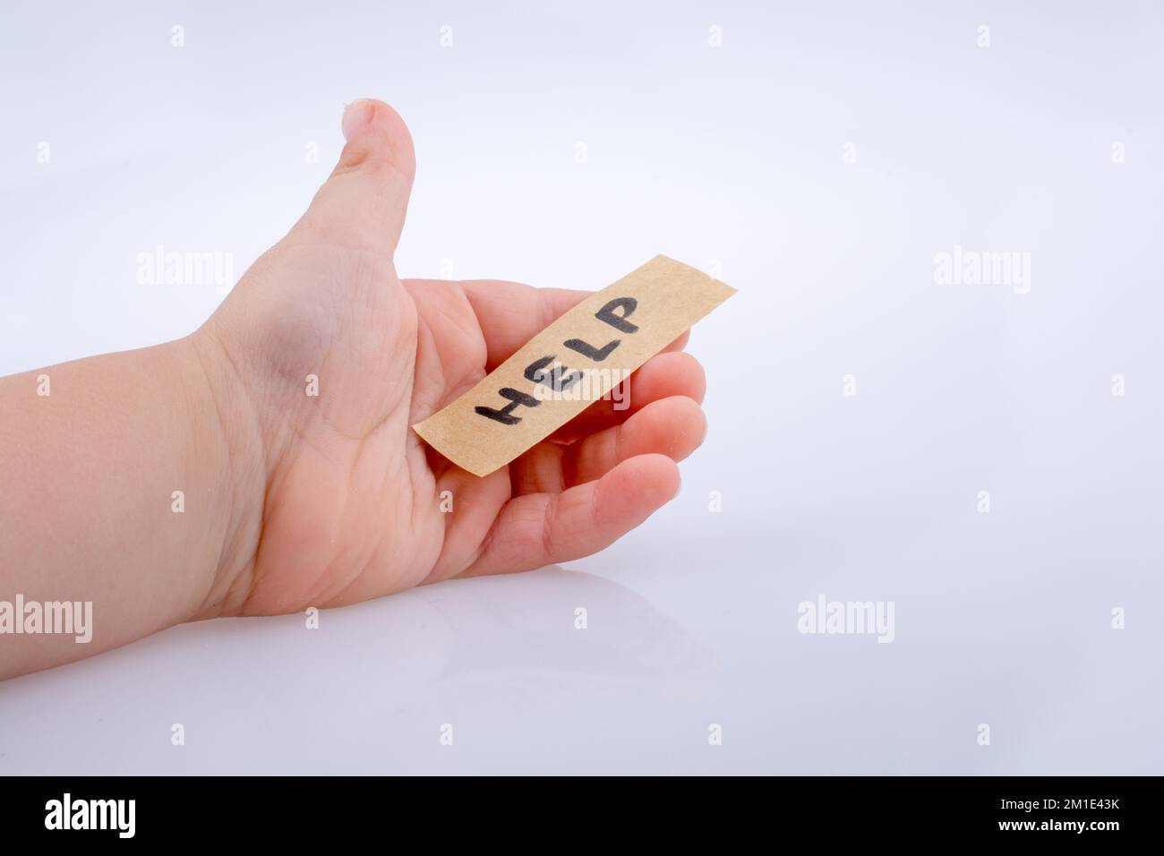 Help word on a piece paper in hand Stock Photo - Alamy