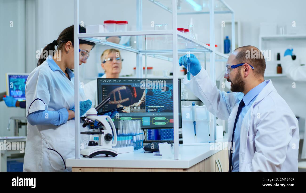 Team of medical research scientists conducting vaccine development with ...