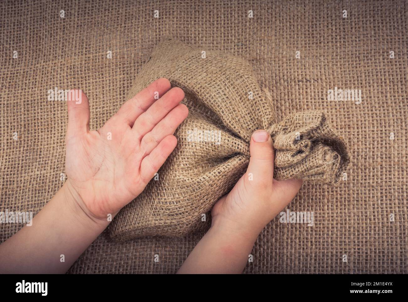 Hand holding an empty little sack made of linen Stock Photo - Alamy