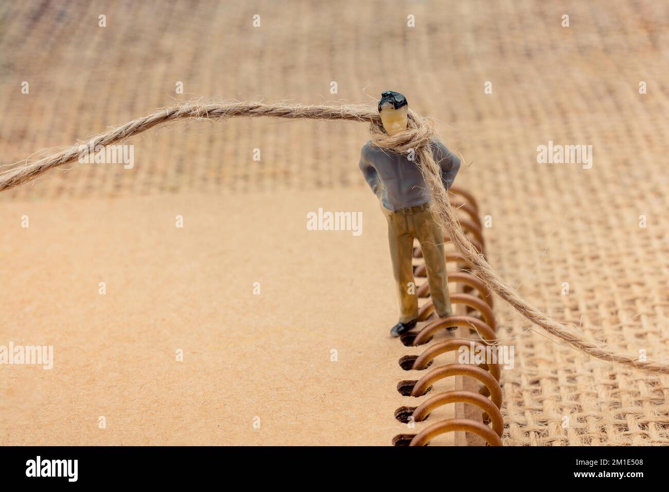 Figurine man with a rope on the neck Stock Photo - Alamy