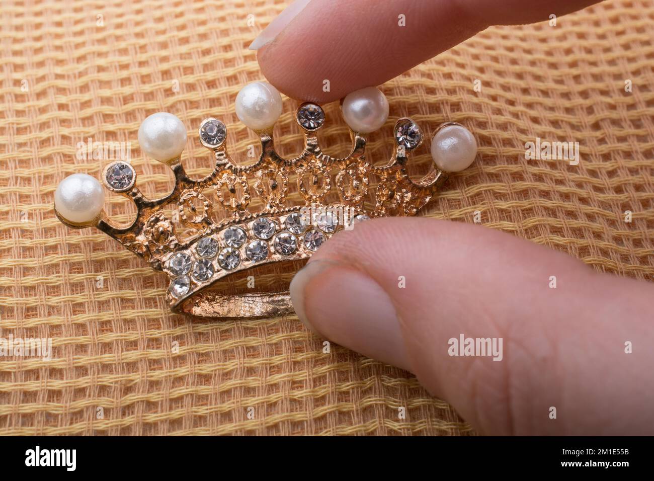 Hand holding a little model crown in hand Stock Photo - Alamy