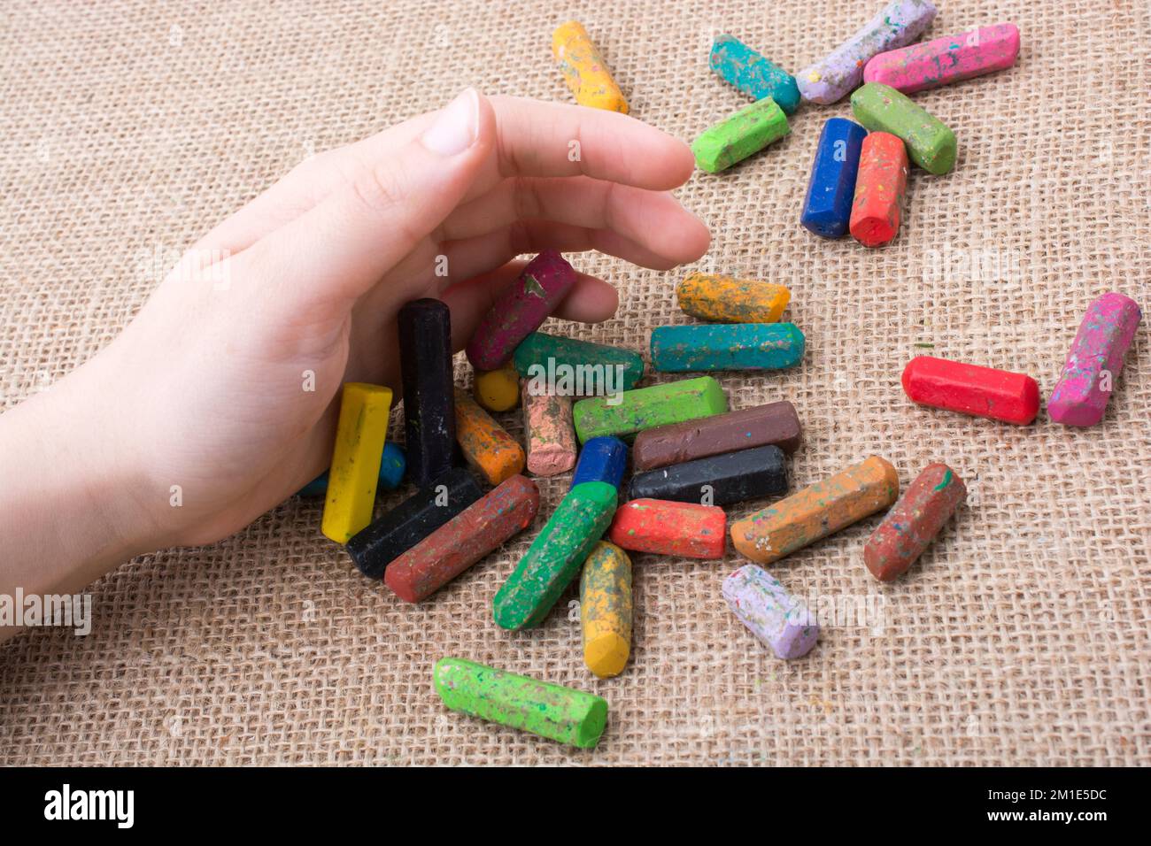 Used color crayons and a hand holding some Stock Photo - Alamy