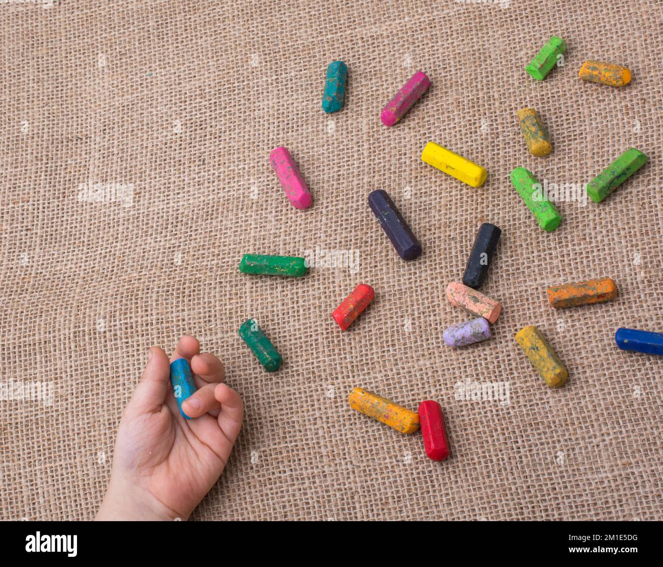 Used color crayons and a toddlers hand holding one Stock Photo - Alamy
