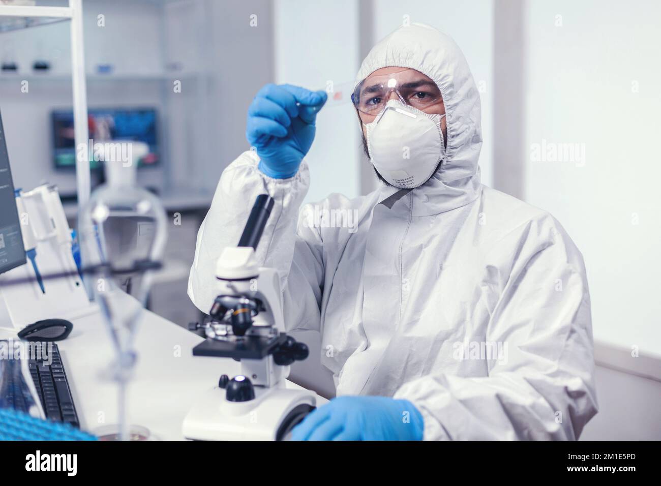 Experienced medical researche analyizing blodd sample on microscop ...